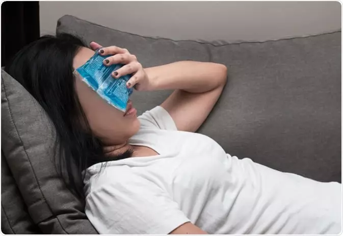 Femme avec sac de glace pour soulager la migraine. Crédit d'image : Baranq/Shutterstock